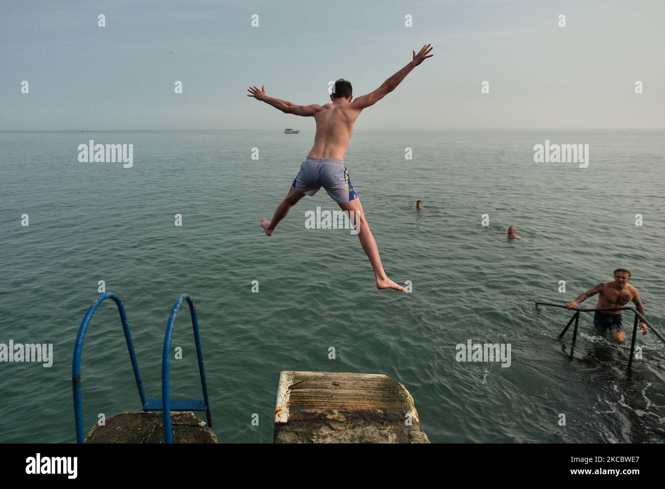 A swimmer jumps into the sea at the Vico bathing place, Hawk Cliff, in ...