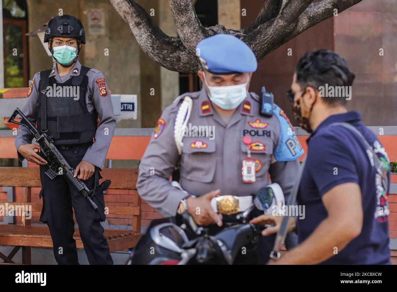 Armed Indonesian national police guards the gate of Bali Police ...
