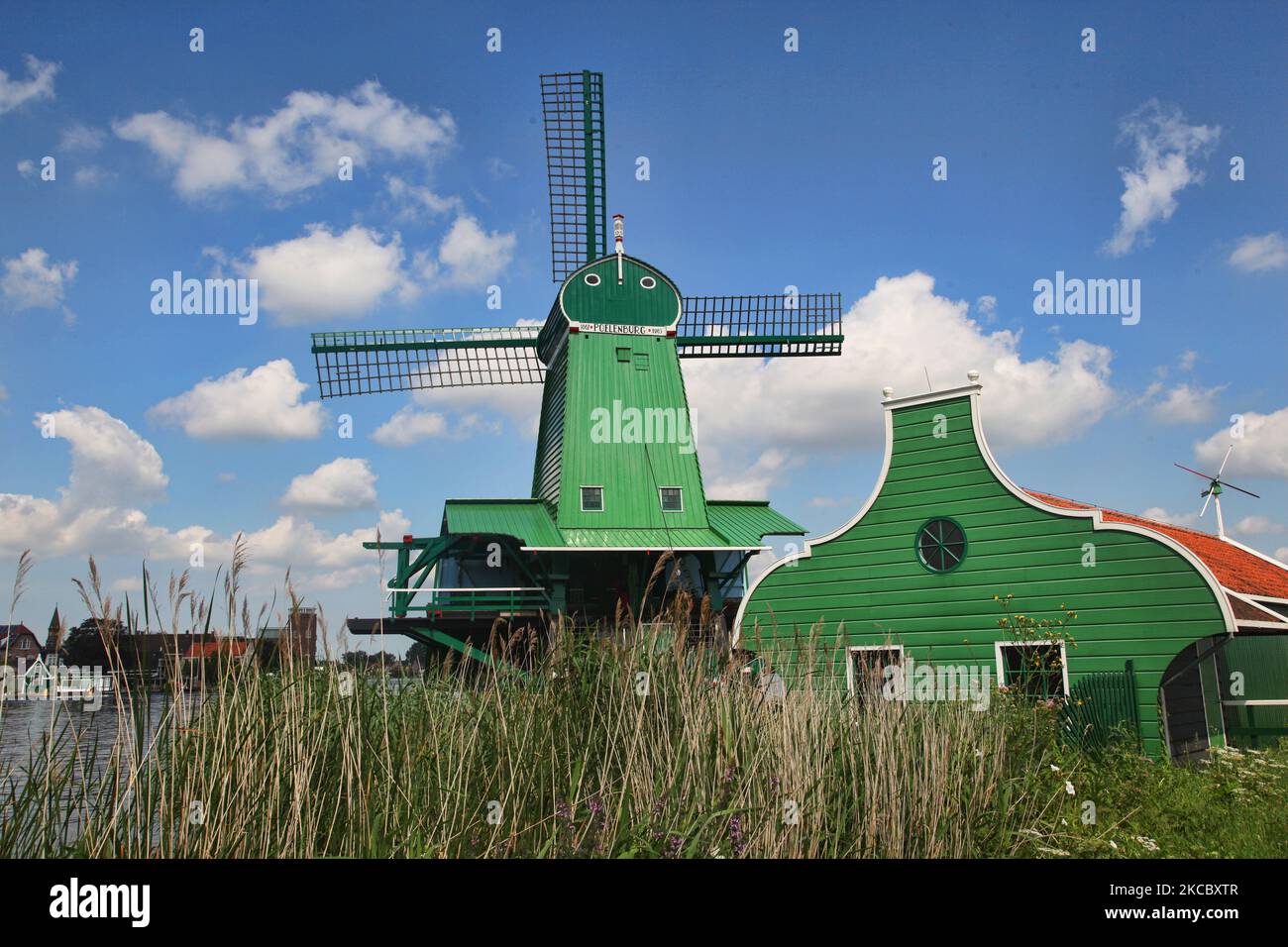 Windmill along a canal in the small town of Zaanse Schans, Holland ...