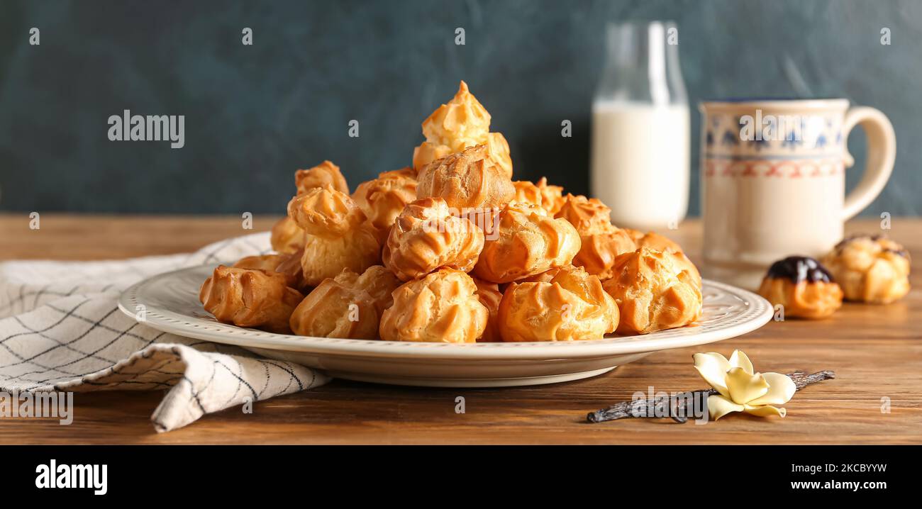 Plate of delicious profiteroles on wooden table Stock Photo - Alamy