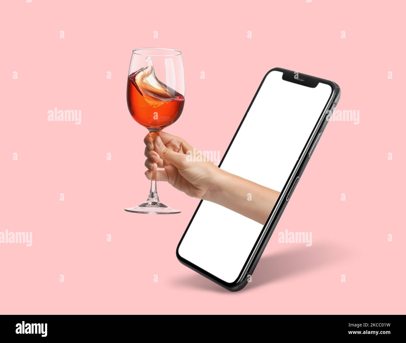 Female hand holding glass of splashing wine through screen of mobile ...