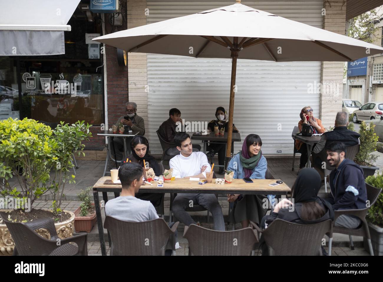 Iranian youth sit in an outdoor cafe in northern Tehran during the day ...