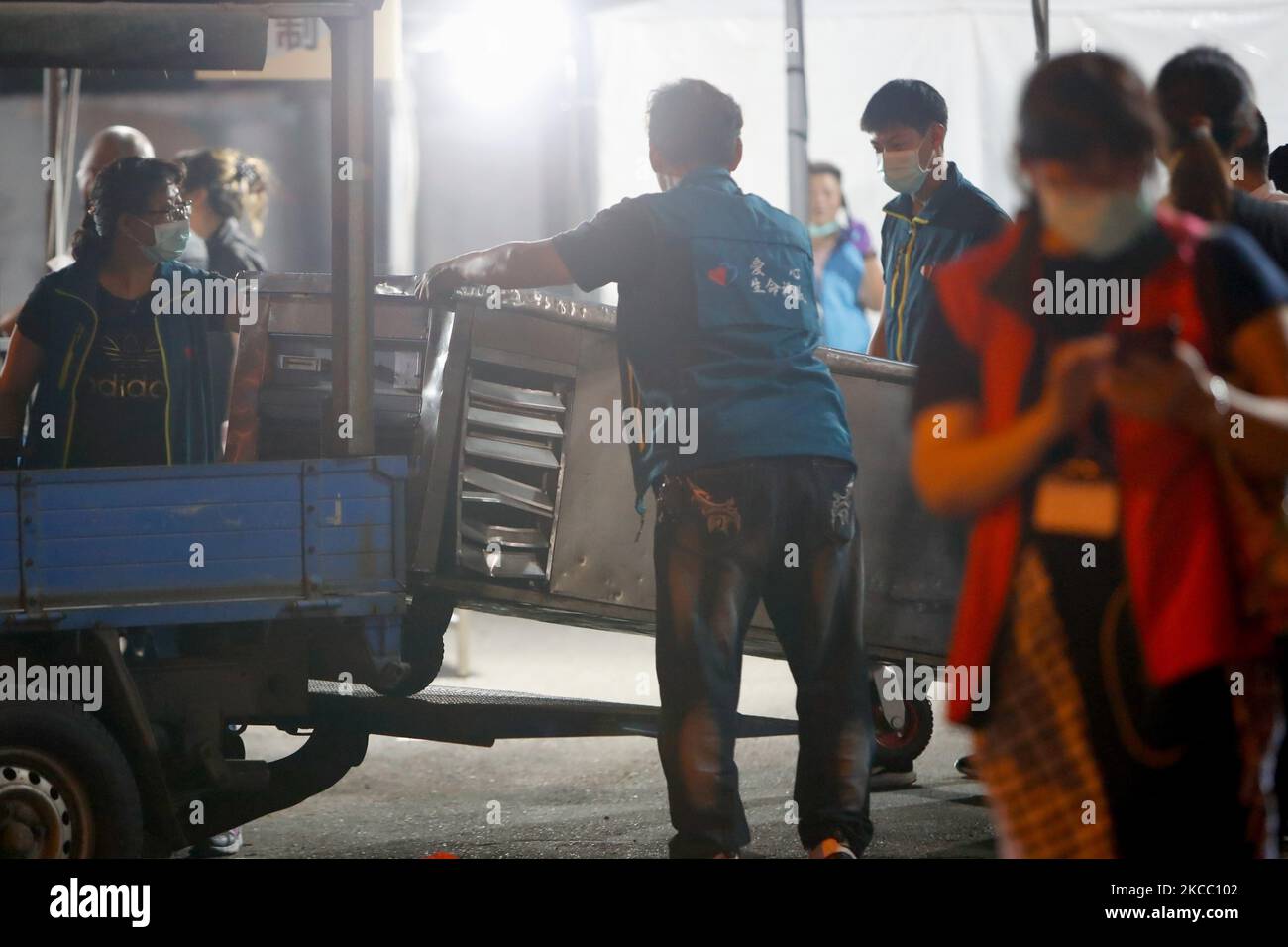 Funeral home workers move a fridge containing disassembled remains and ...