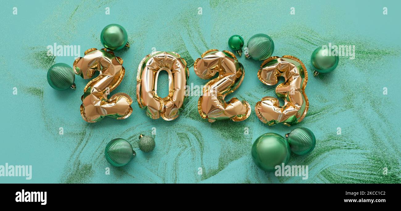 Figure 2023 made of balloons and Christmas balls on green background ...