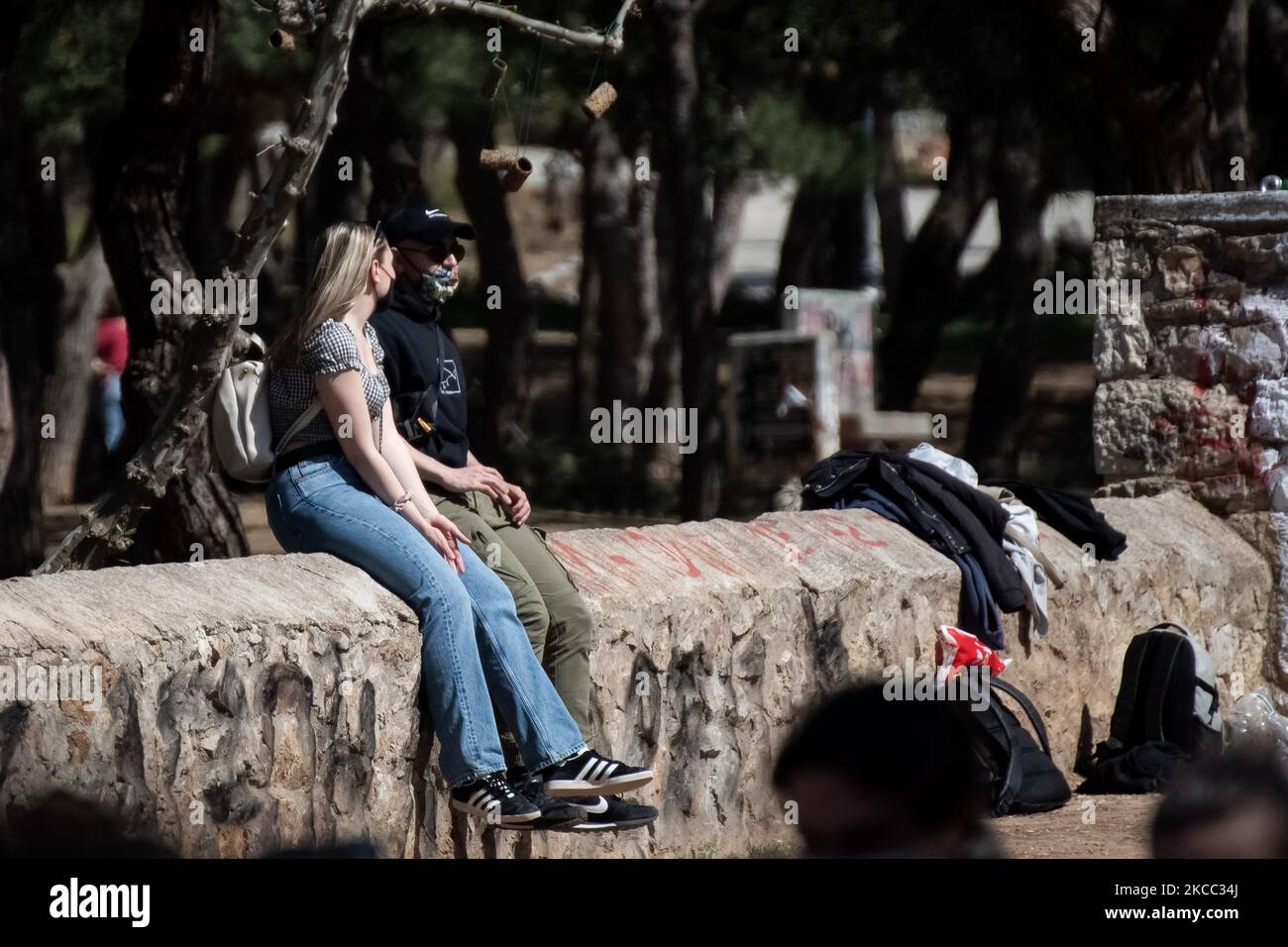People are relaxing in a park at the area of Kaisariani, after the new ...