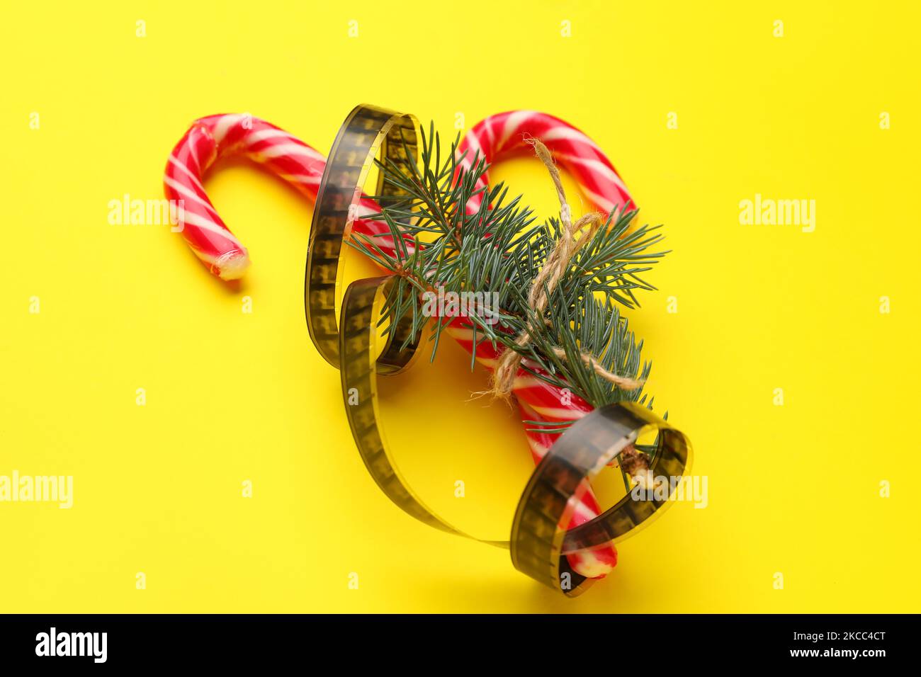 Candy canes with film reel and fir branches on yellow background Stock ...