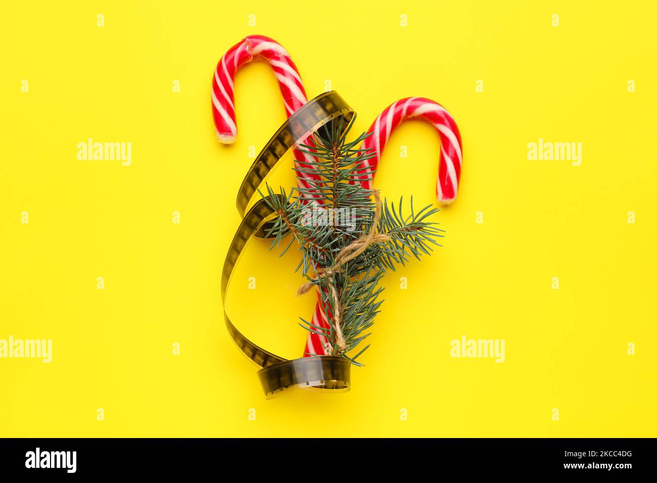Candy canes with film reel and fir branches on yellow background Stock ...