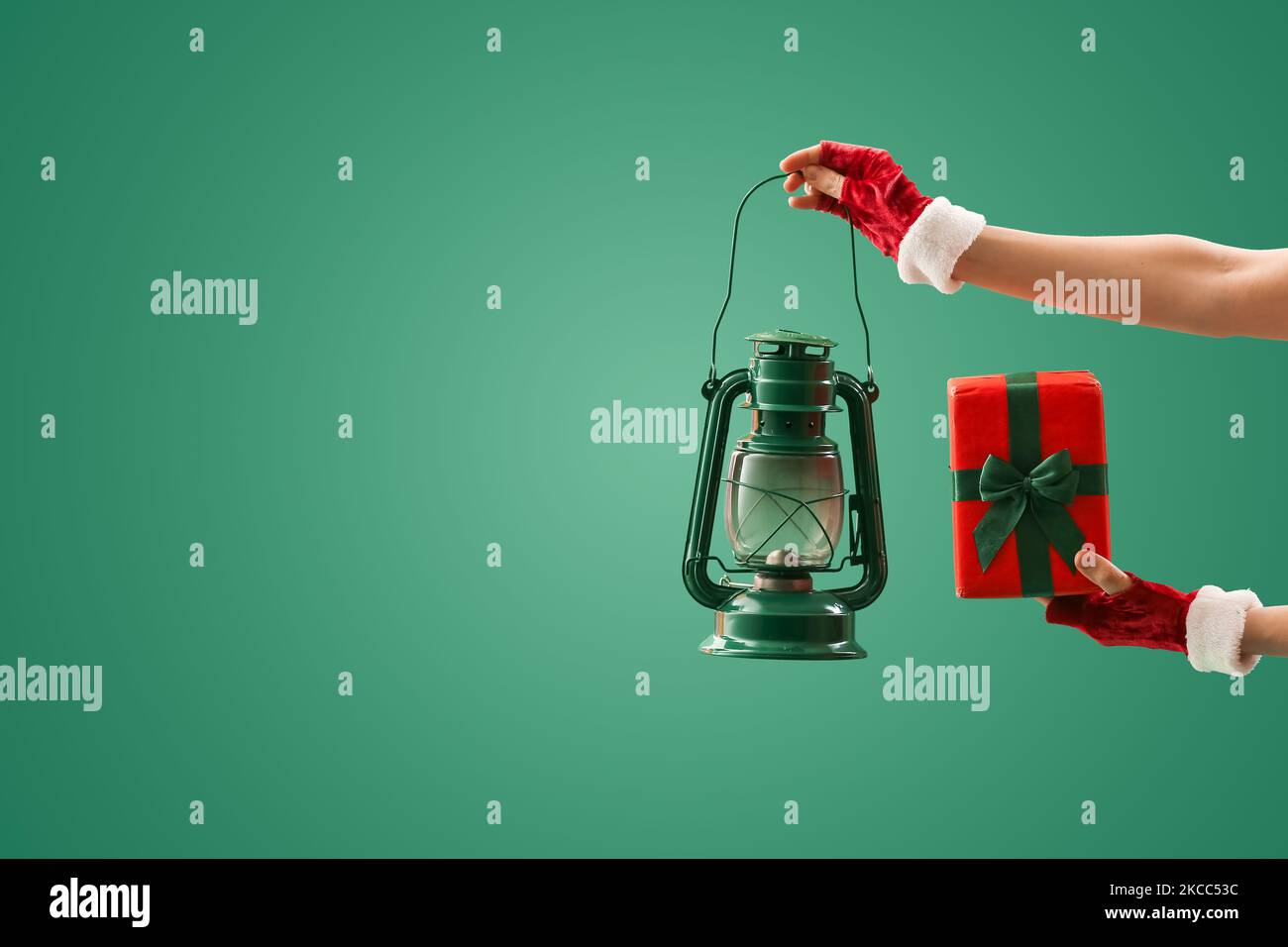 Woman with Christmas gift box and lantern on green background Stock ...