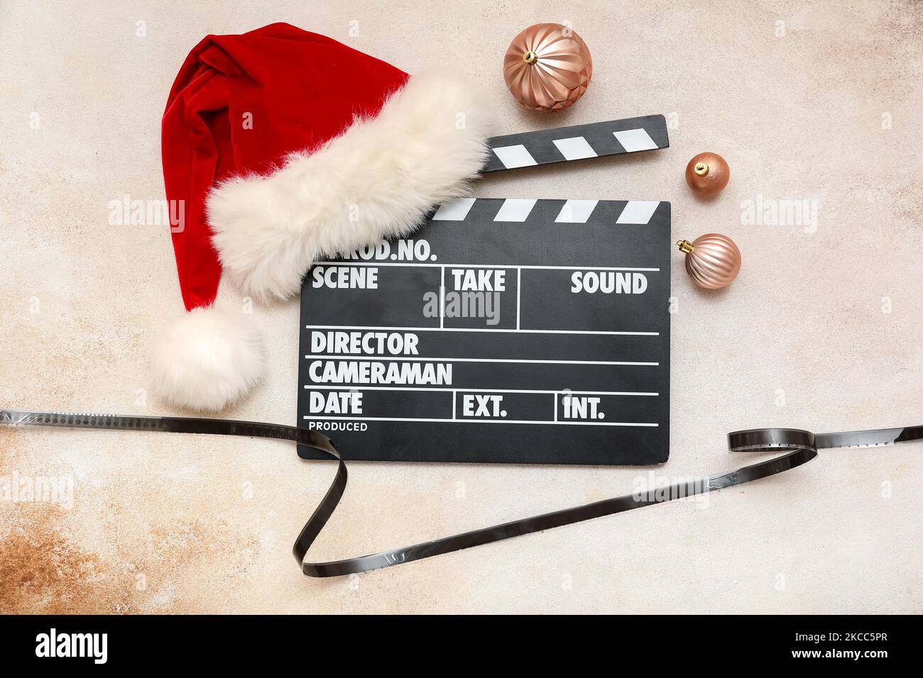 Movie clapper with Santa hat, Christmas balls and film reel on grunge ...