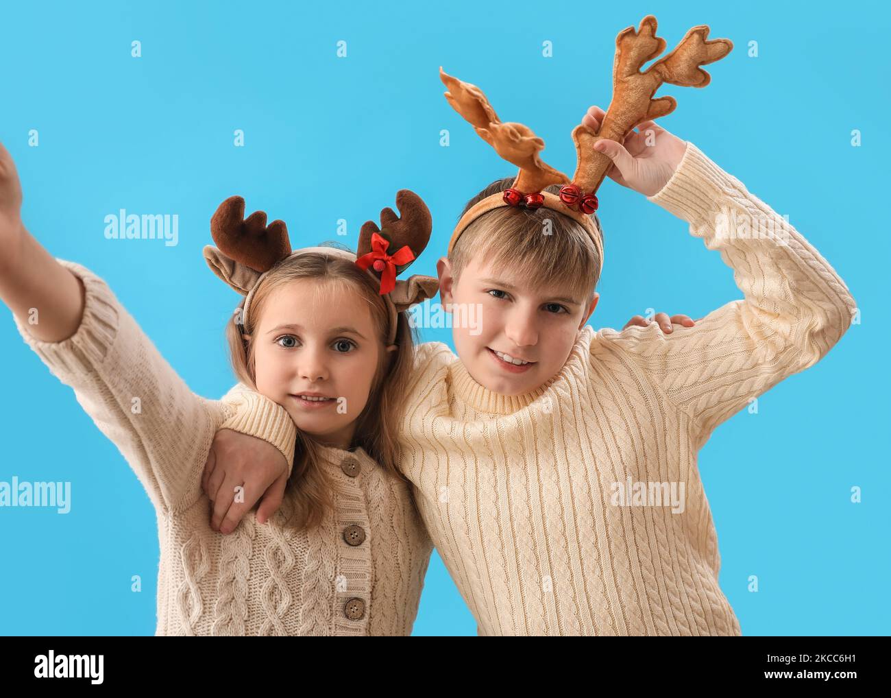 Little children in reindeer horns on blue background Stock Photo - Alamy