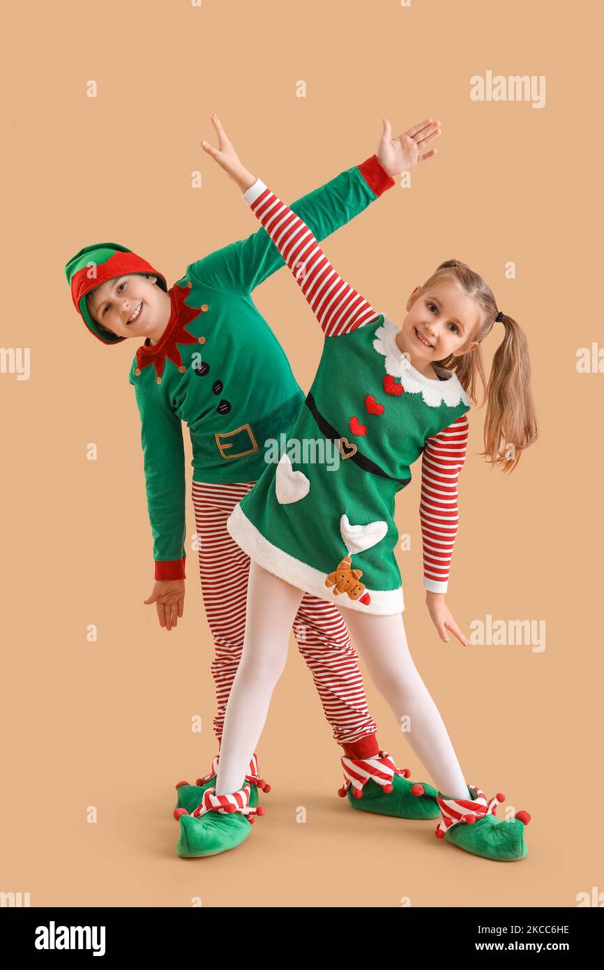 Little children dressed as elves on beige background Stock Photo - Alamy