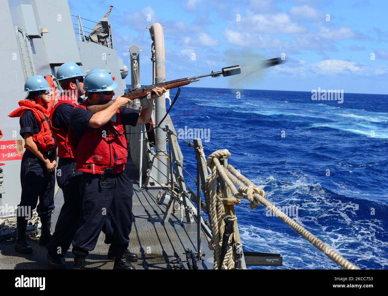 Gunner's Mate fires the shot line from the guided-missile destroyer USS ...