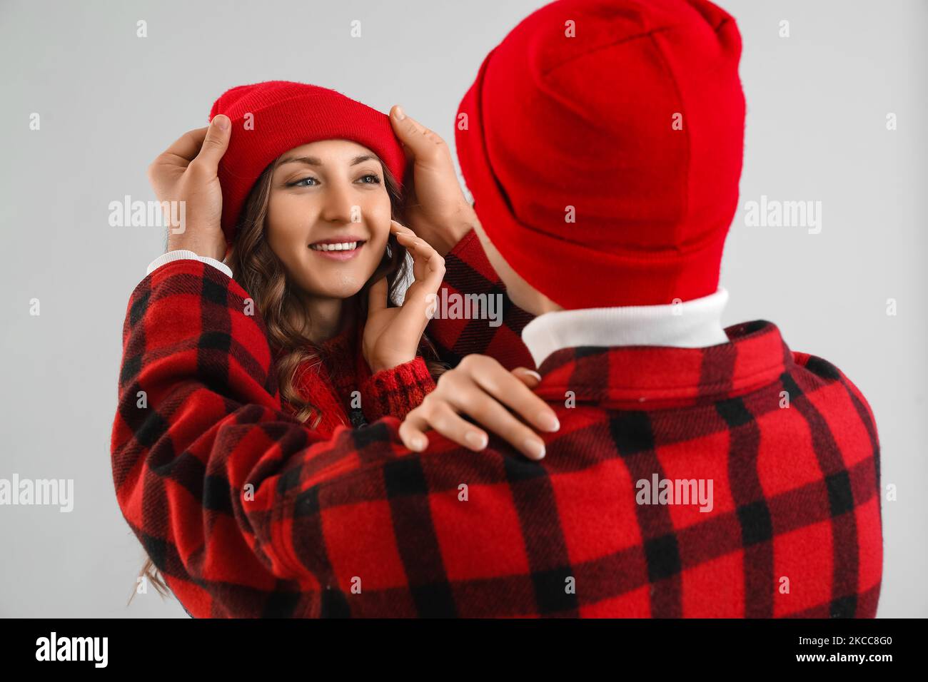 Loving couple in warm clothes on grey background Stock Photo - Alamy