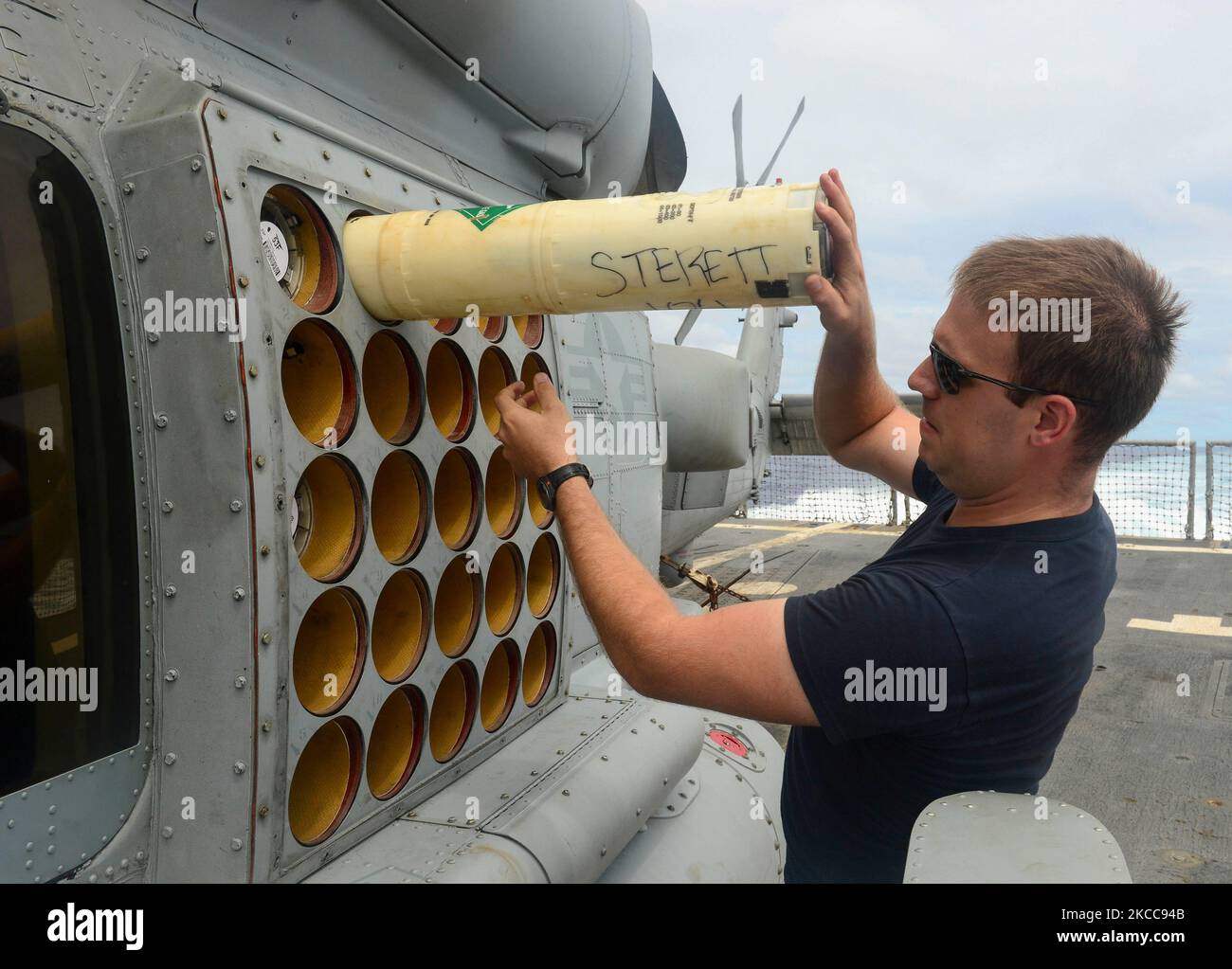 Aviation Electrician's Mate loads passive sonar buoys into an HM-60R ...