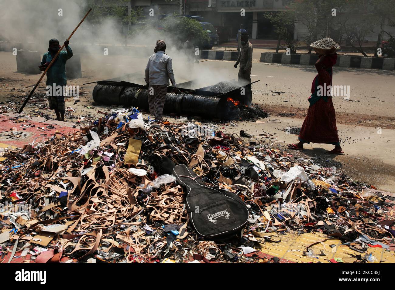 Construction workers working on a road that creates toxic smoke as they ...