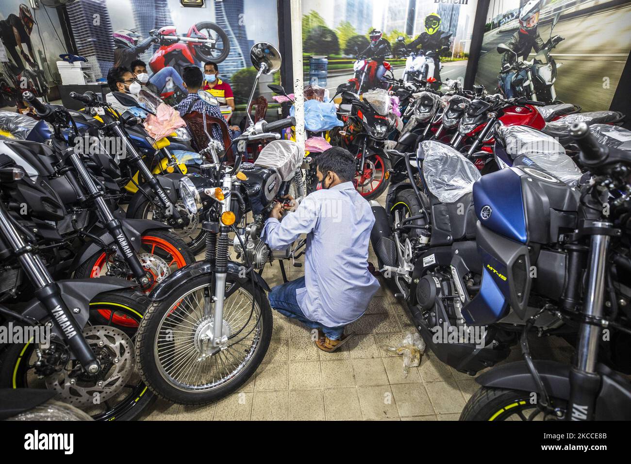 A shopkeeper changing battery of a bike in a showroom in Dhaka on April ...