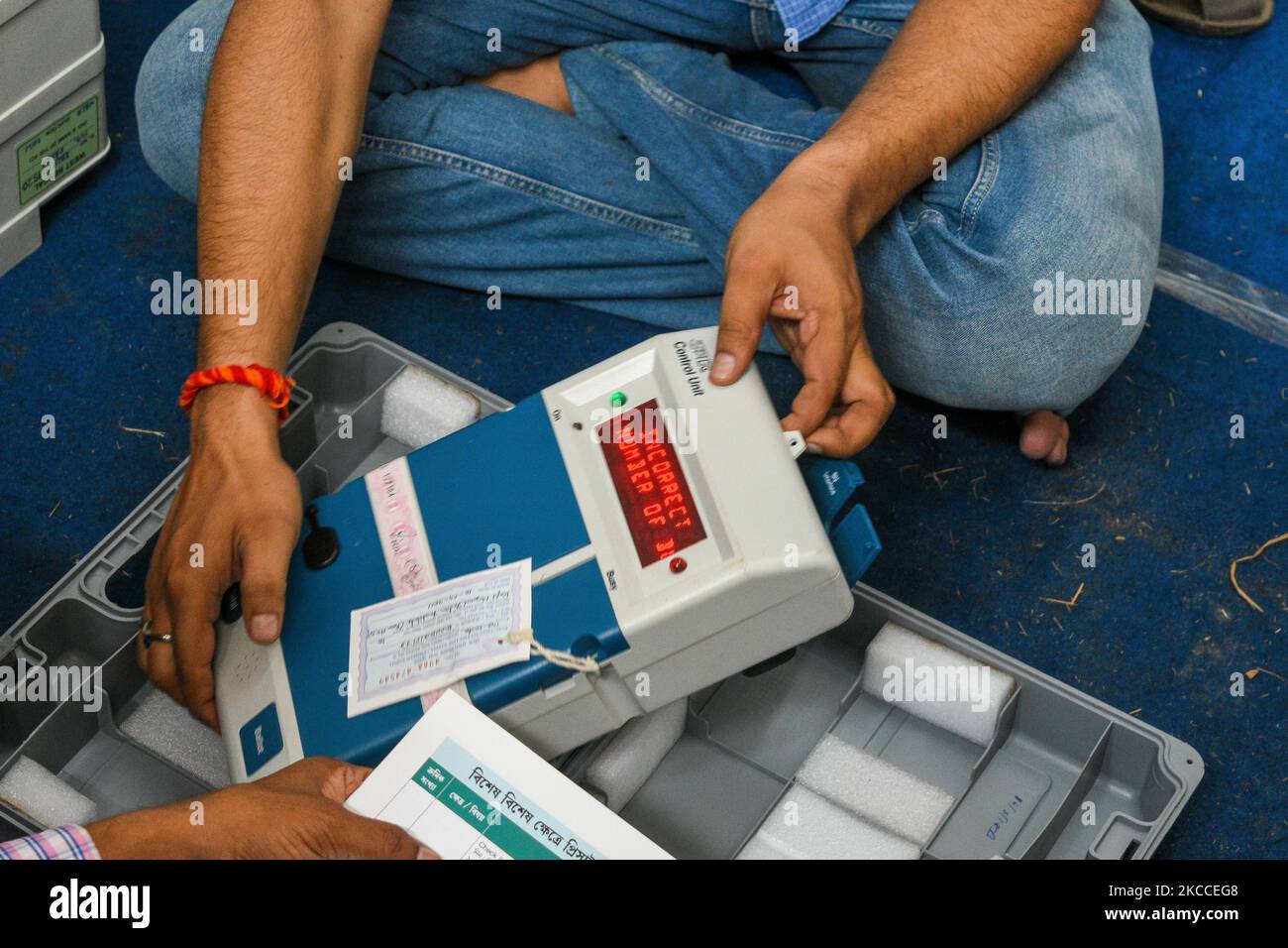 A polling officer checking the control unit of an Electronic Voting ...