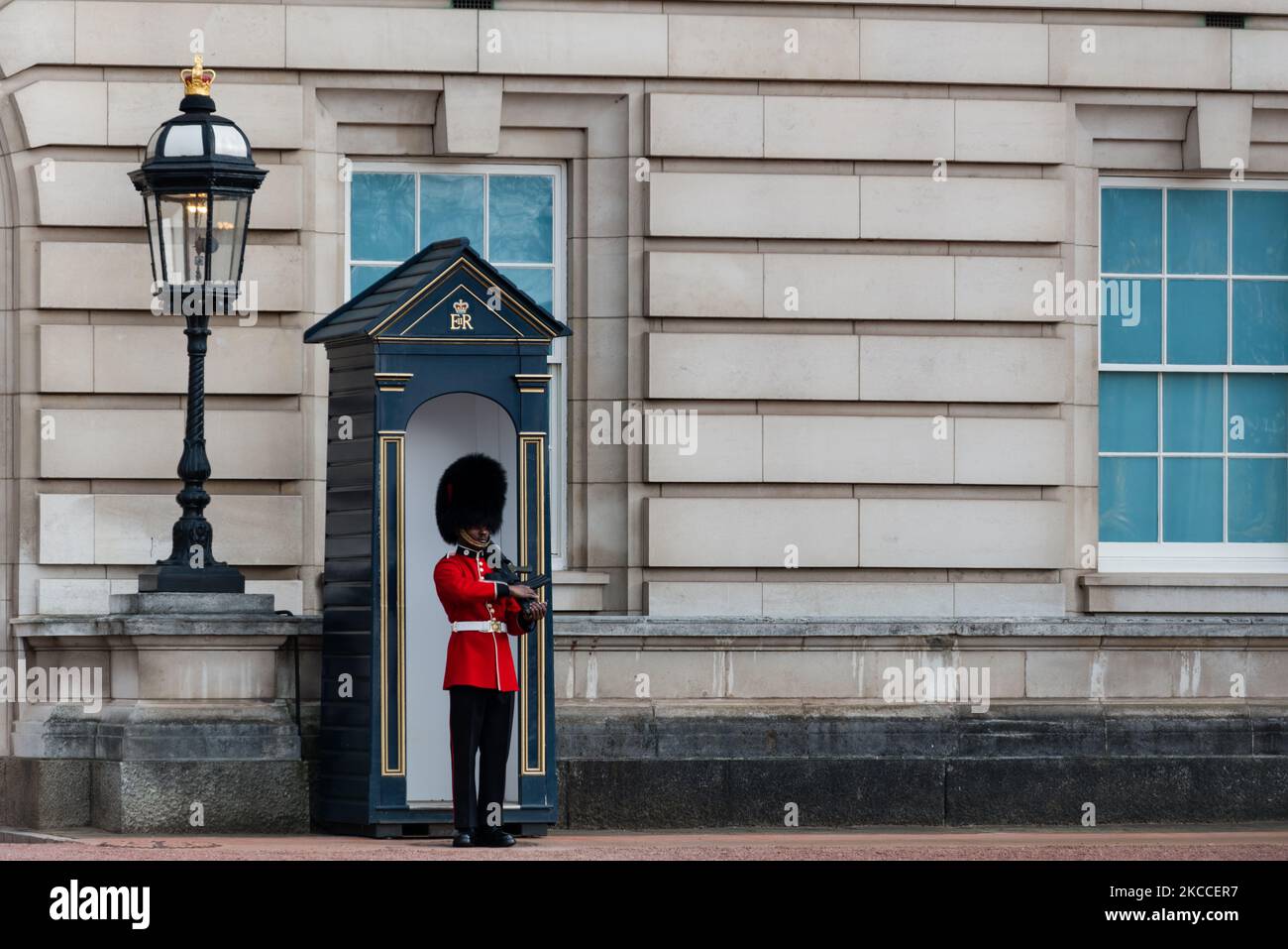 A member of the Queen's Guard stands on duty outside Buckingham Palace ...