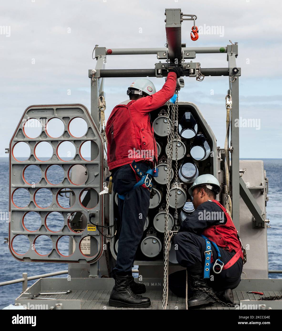 Fire Controlmen load a missile into a RIM-116 Rolling Airframe Missile ...