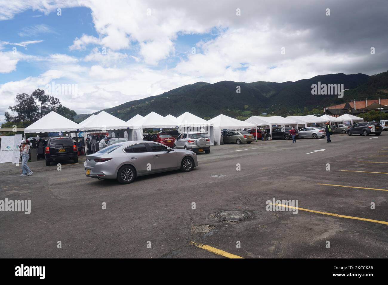 People wait inside their cars to be vaccinated with the Pfizer-BioNTech ...