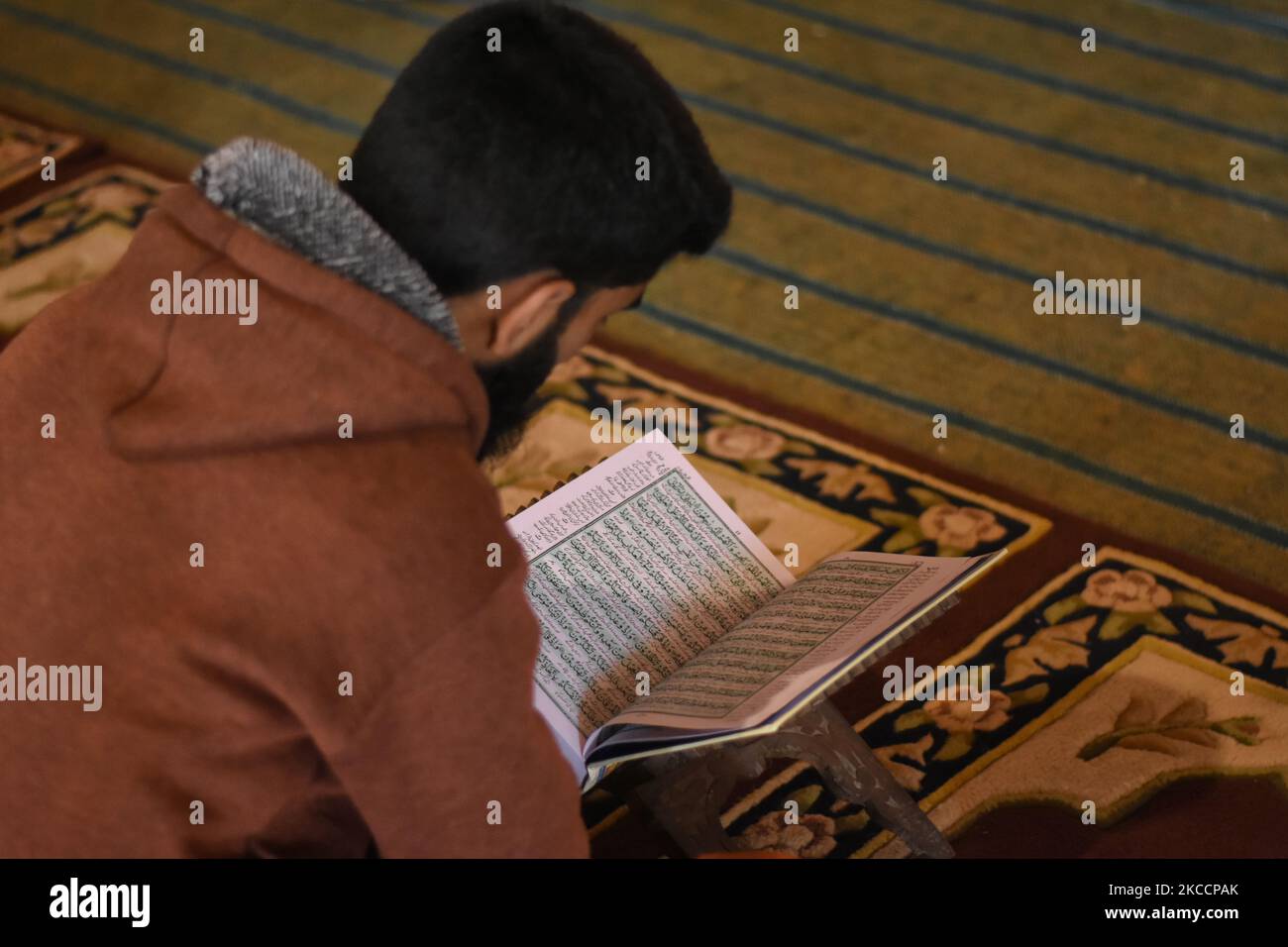 A Kashmiri boy reads Holy Quran on the first day of Ramadan inside ...