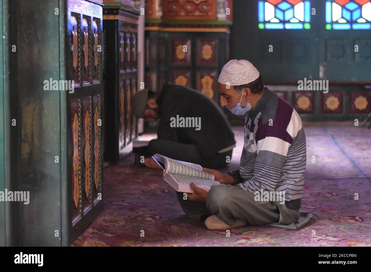 A Kashmiri man reads Holy Quran on the first day of Ramadan inside a ...