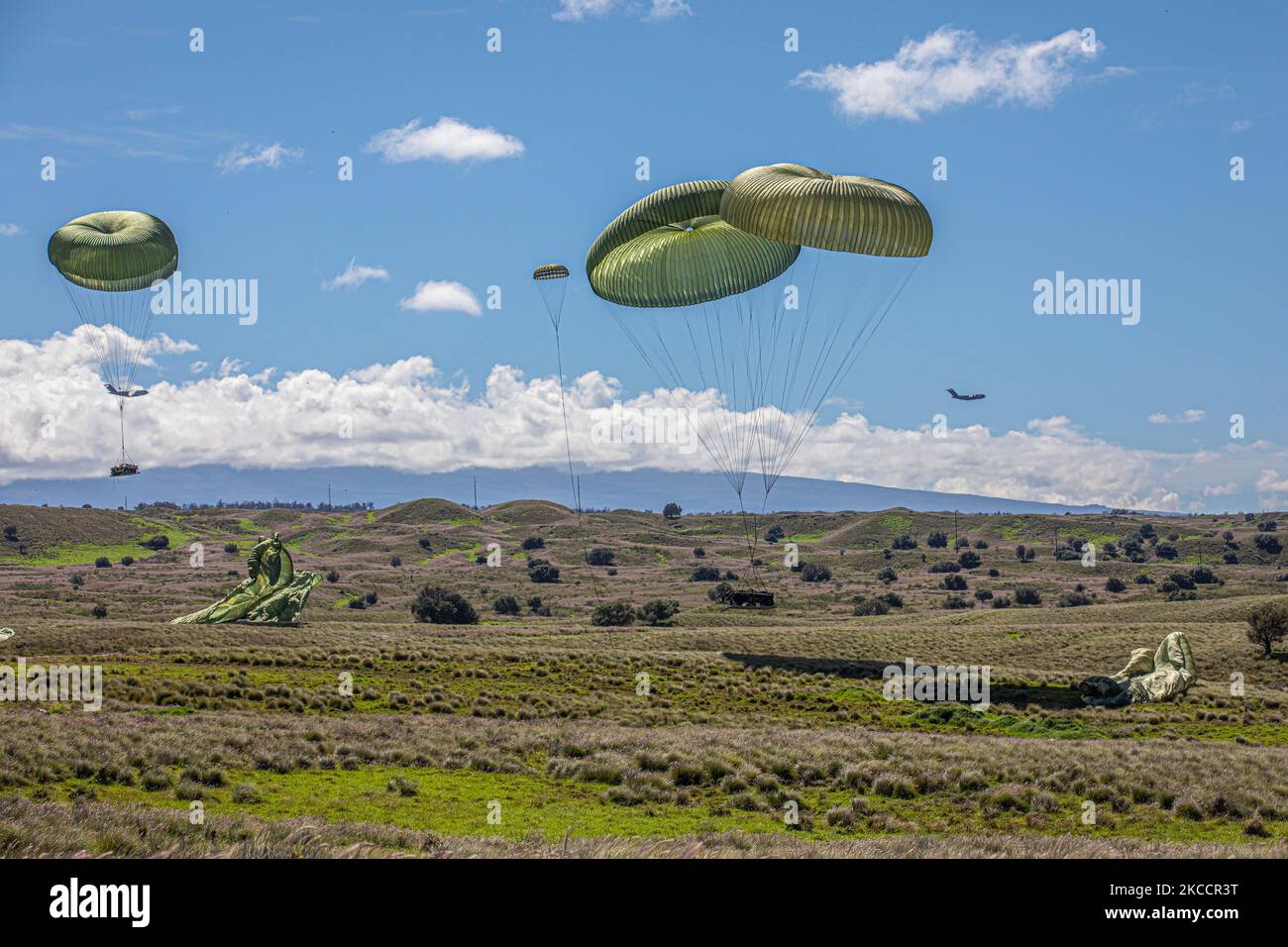 U.S. Air Force C-130s conduct an airdrop on Pohakuloa Training Grounds ...