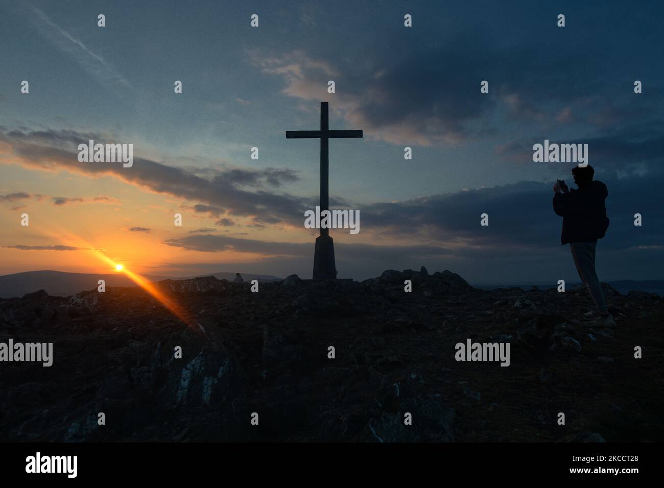 A man takes a photo of the Holy Year Cross on summit of Bray Head at ...