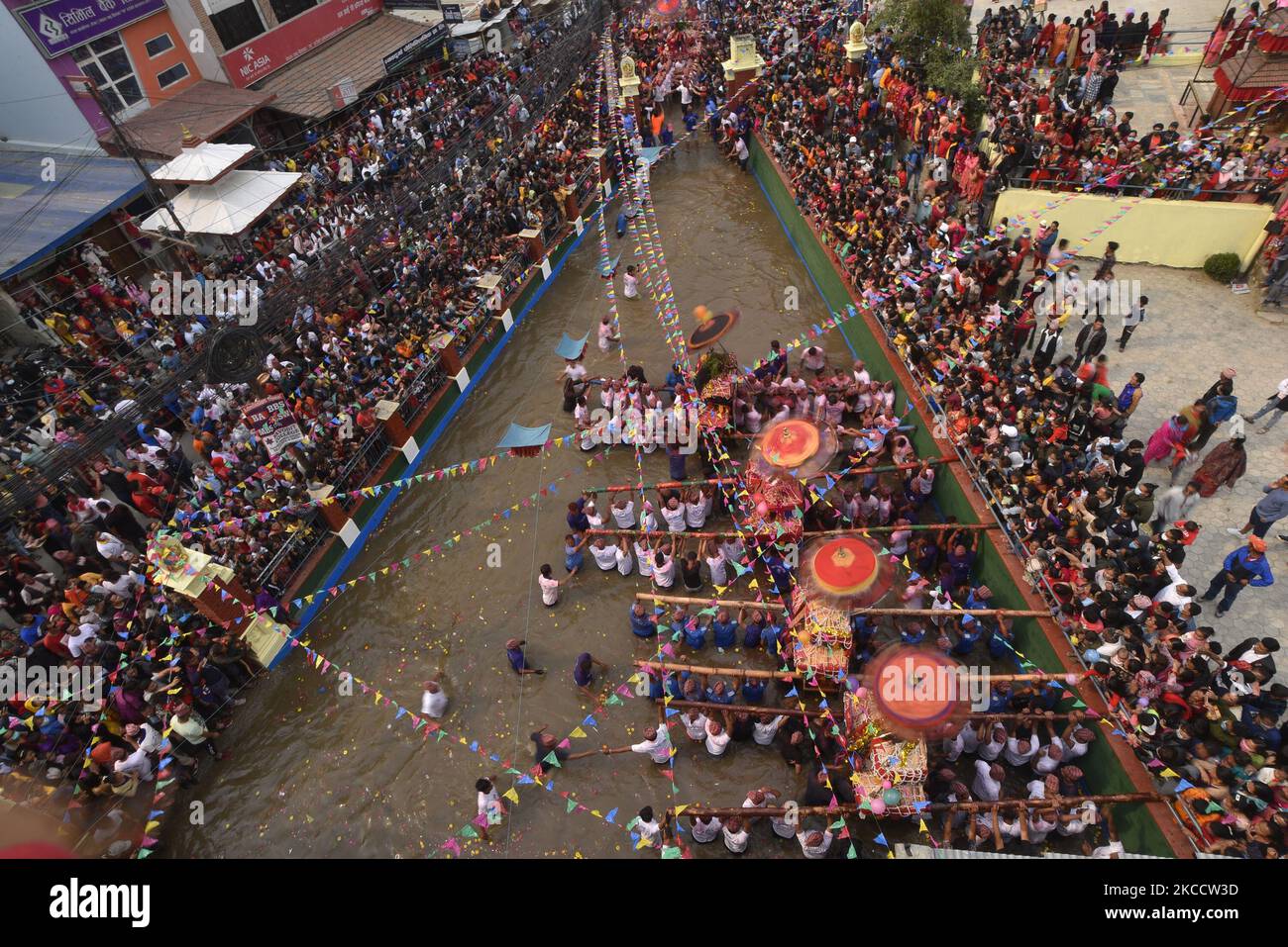 Nepalese devotees carrying the chariot in the pond during the ...