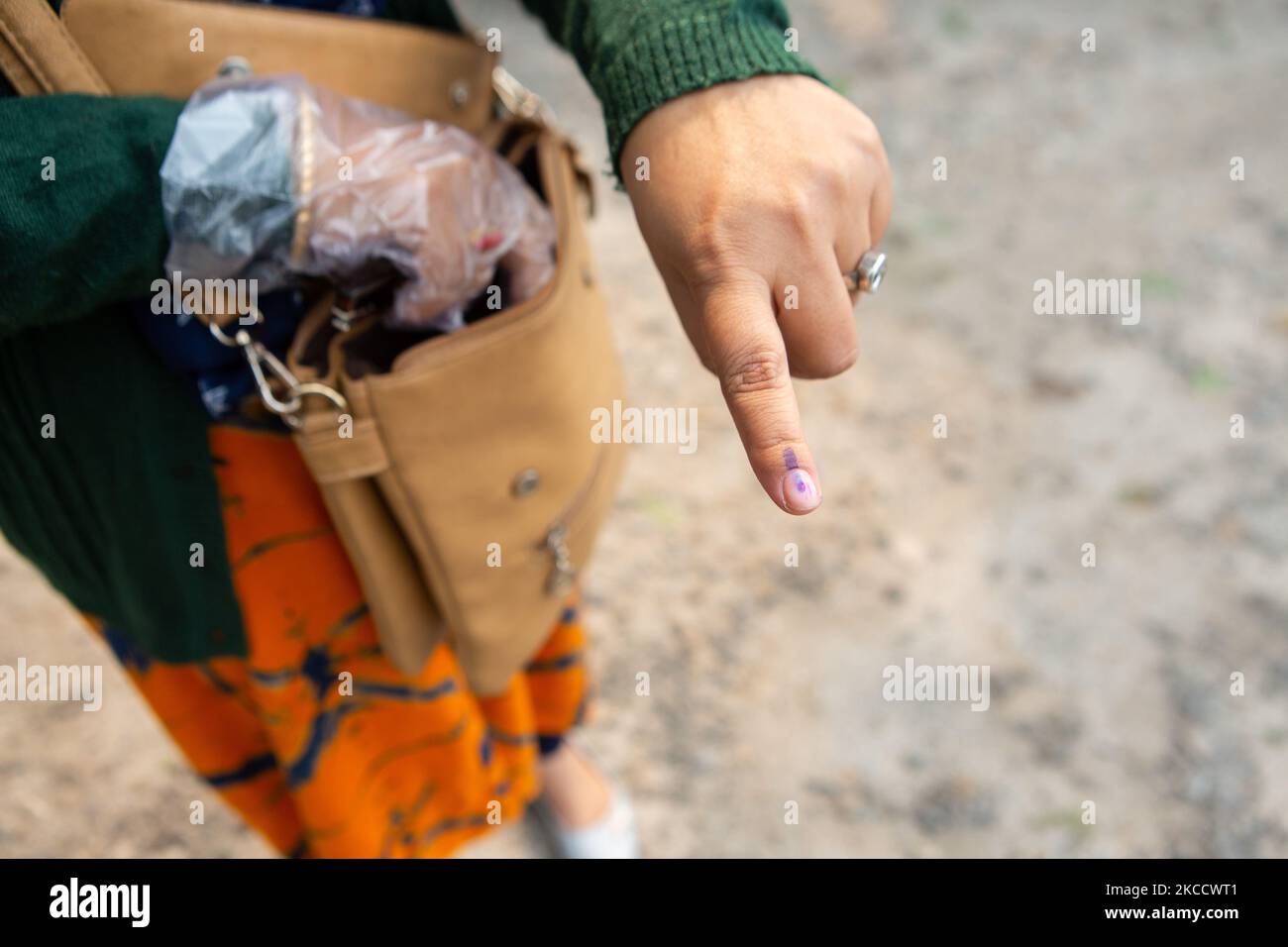 Woman shows her marked finger with indelible ink after casting vote ...