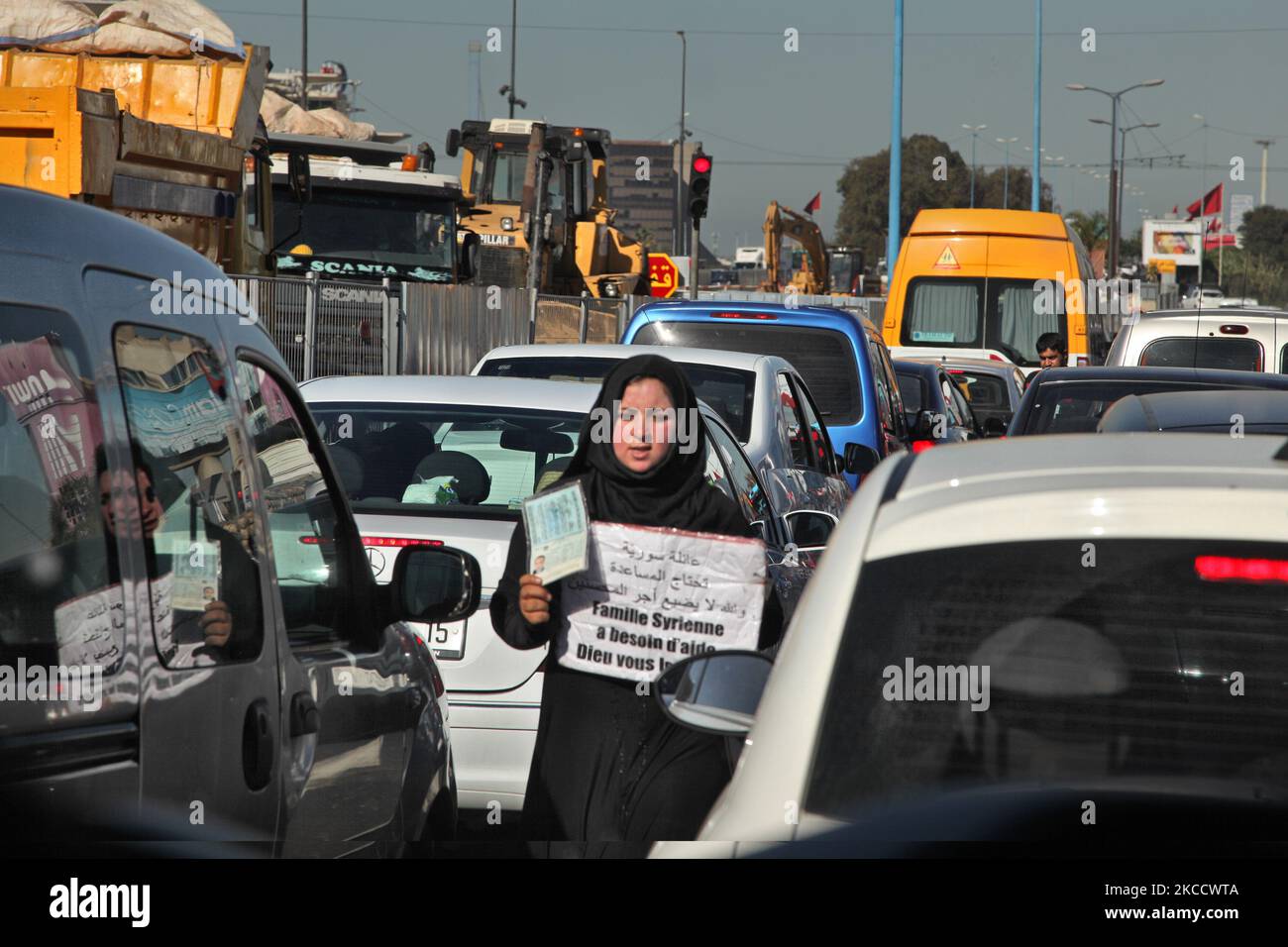 Syrian refugee walks through traffic as she begs for alms from ...