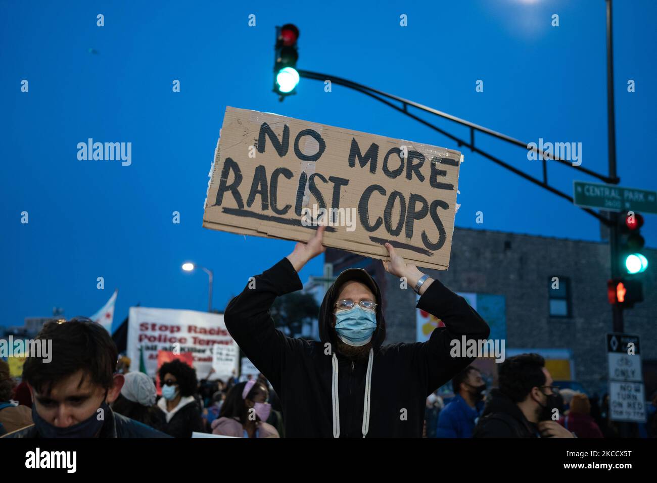 A protester holds a sign as she march through Logan Square neighborhood ...