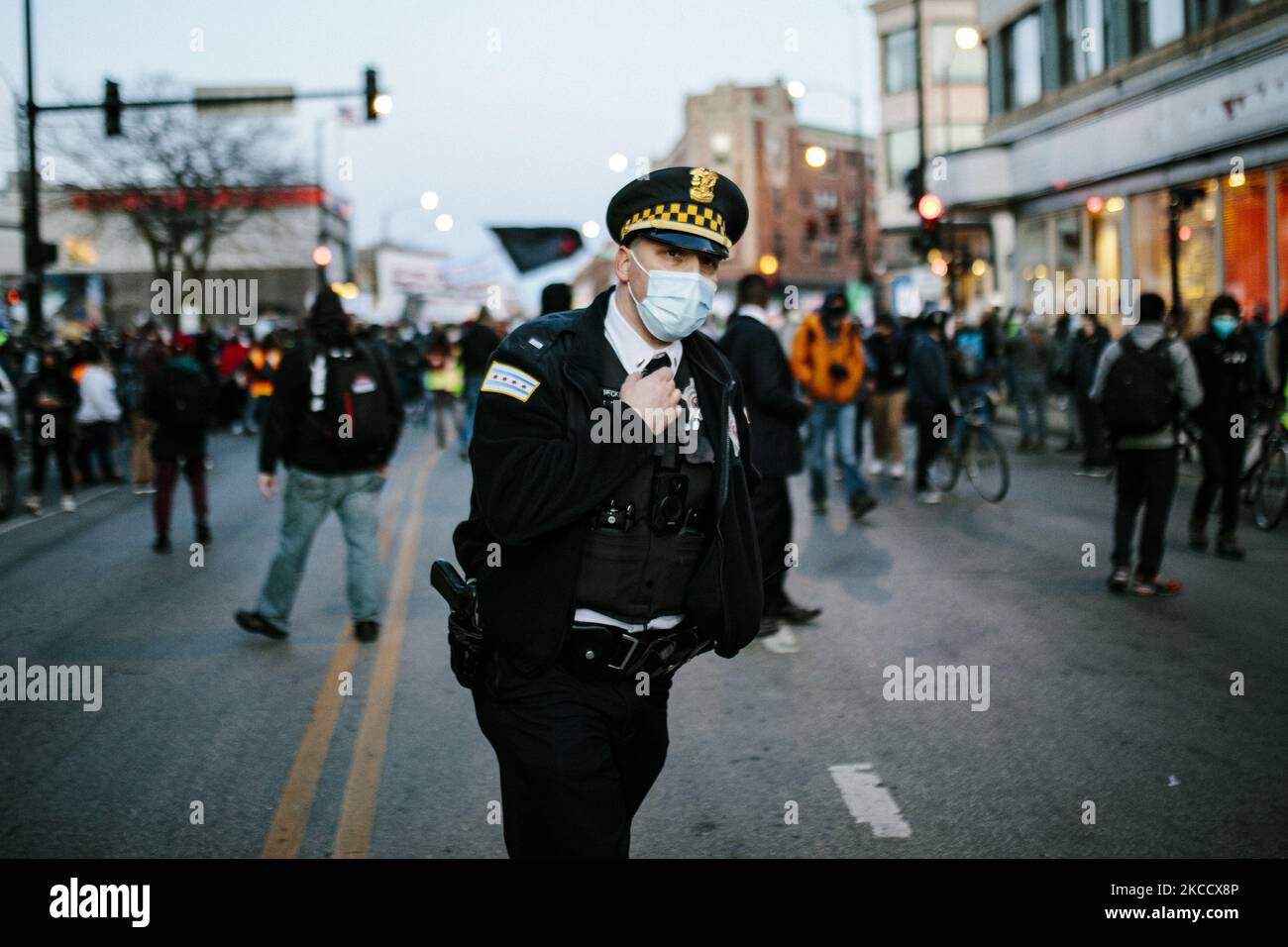 A Chicago Police Officer looks down the street as protesters block ...
