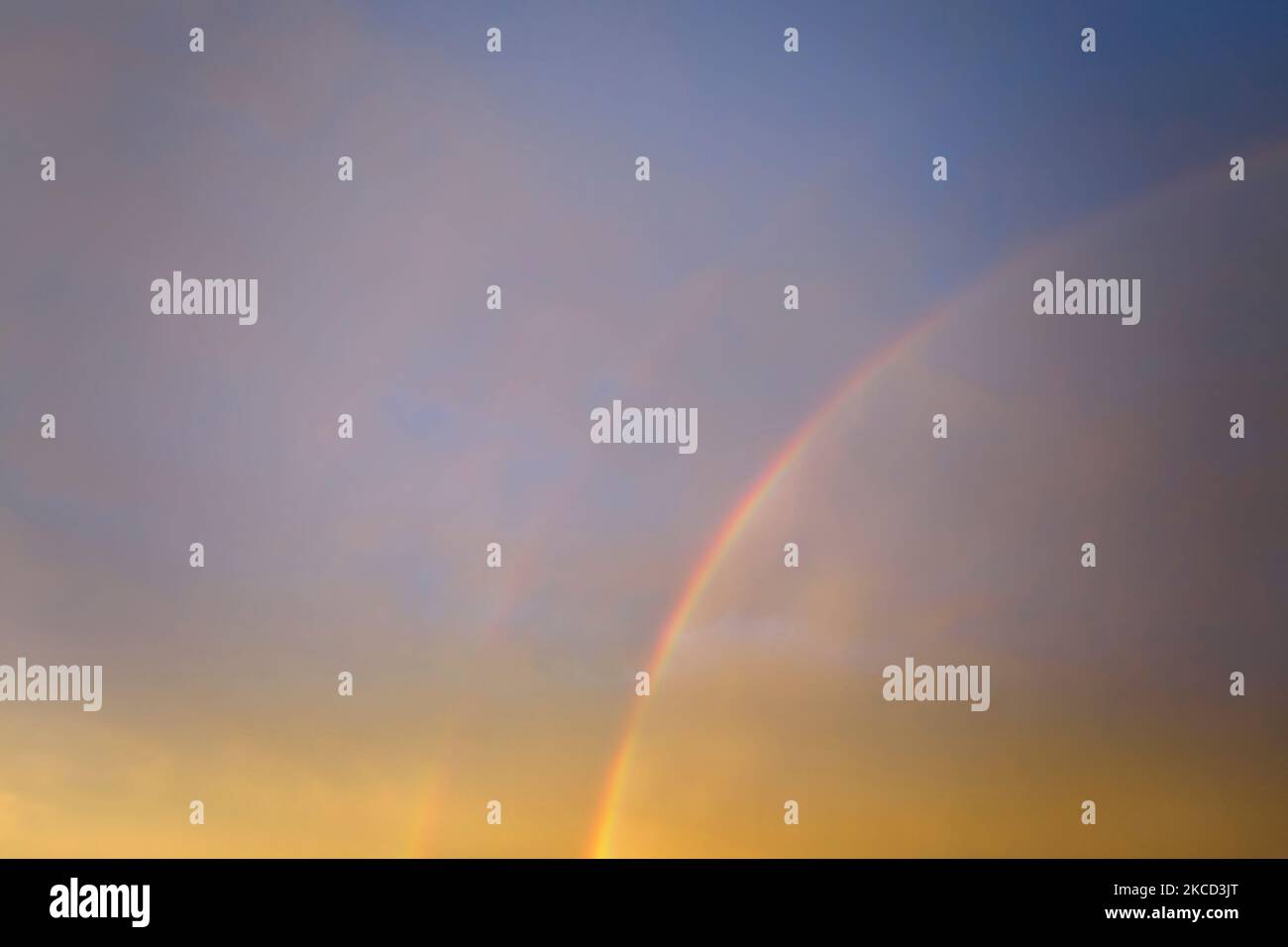 Colorful round rainbow against blue evening sky after heavy ...