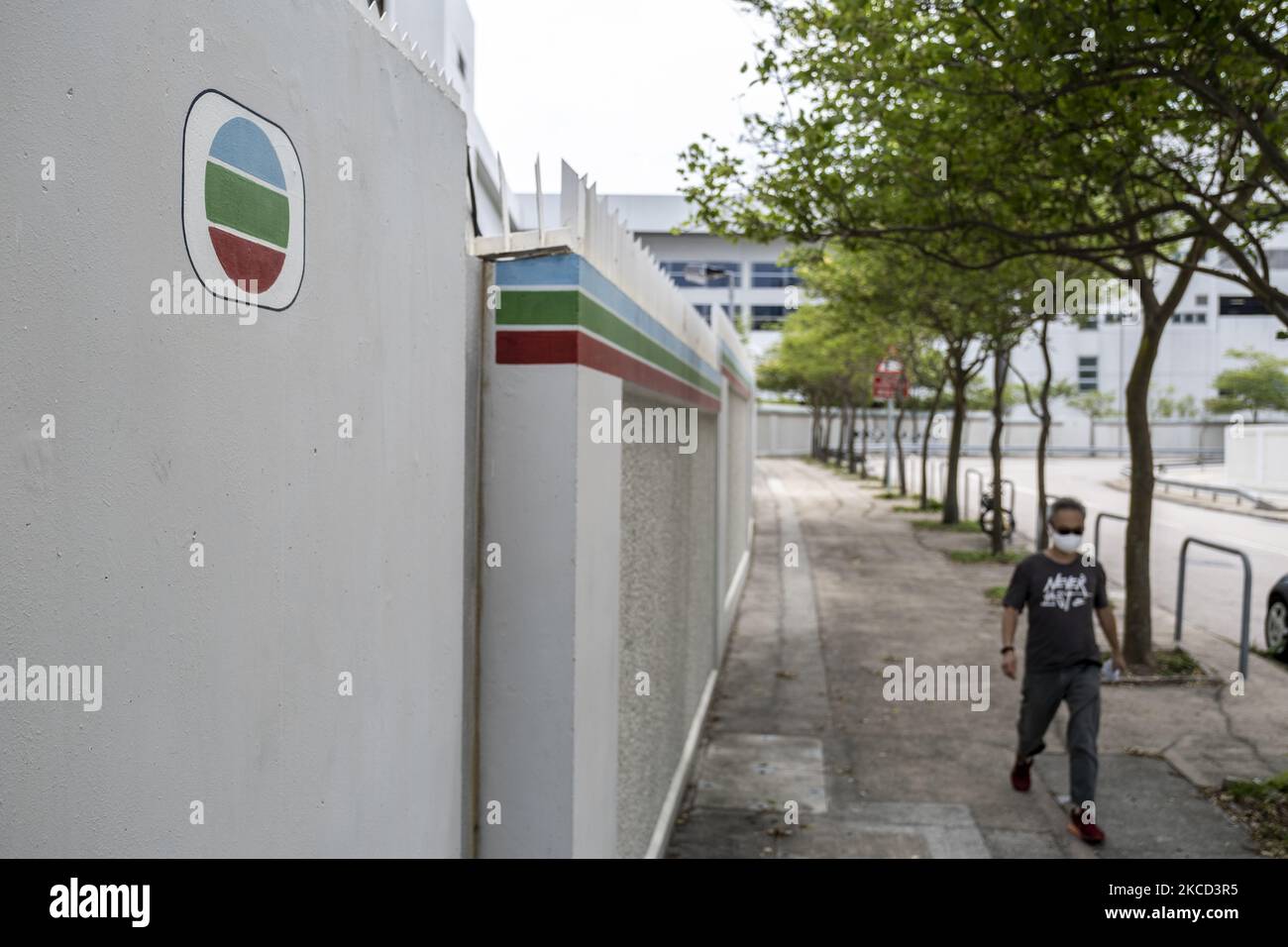 A man walks pass the wall surrounding TVB City, which is where the Hong ...