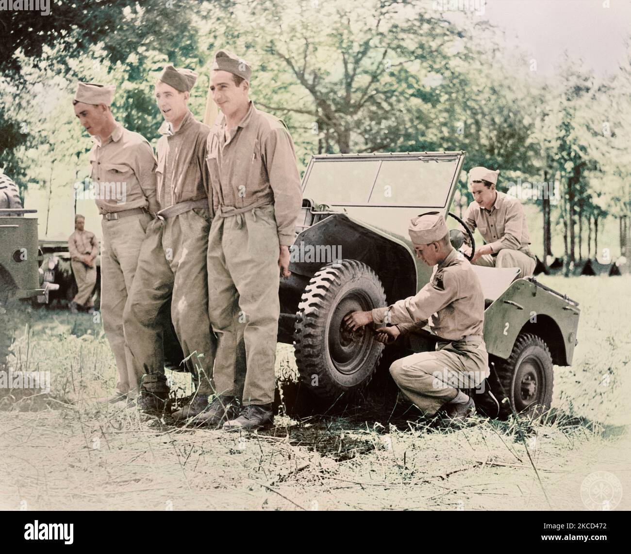 American soldiers lifting a jeep to repair it at their bivouac area ...