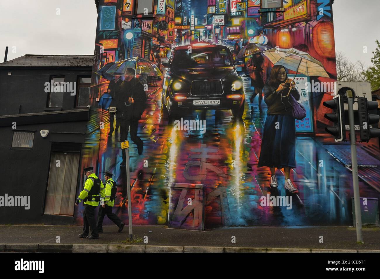 Two Policemen walk past a colorful mural ‘Night Taxi’ by graffiti ...