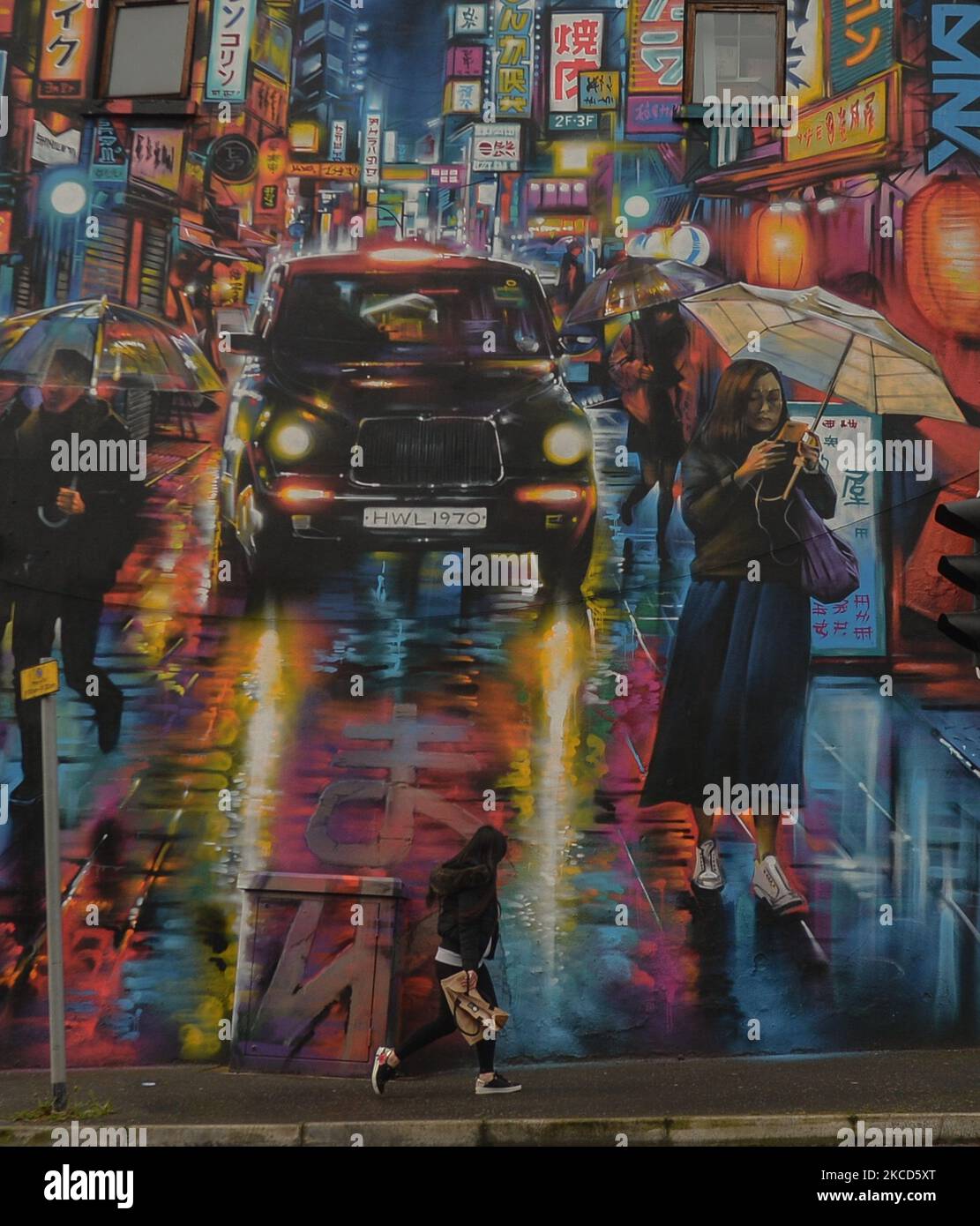 A woman walks past a colorful mural ‘Night Taxi’ by graffiti artist Dan ...