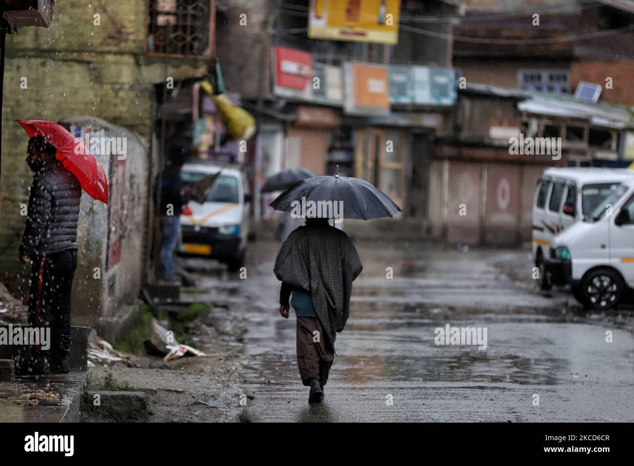 Kashmir men with umbrella on a rainy day amid COVID-19 Coronavirus ...