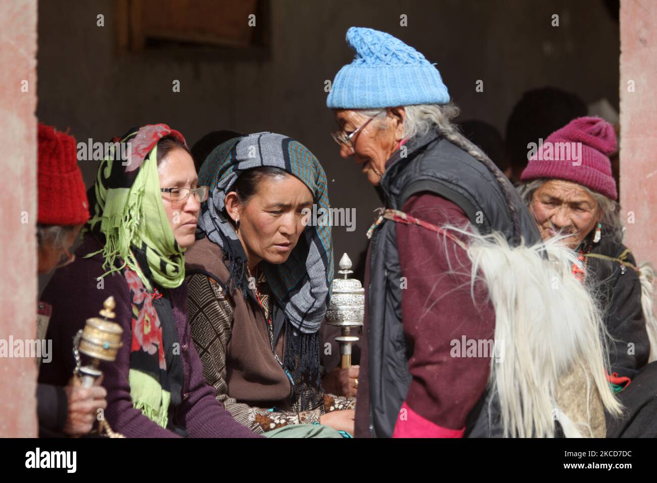 Ladakhi Buddhist women spin hand-held prayer wheels as they watch ...