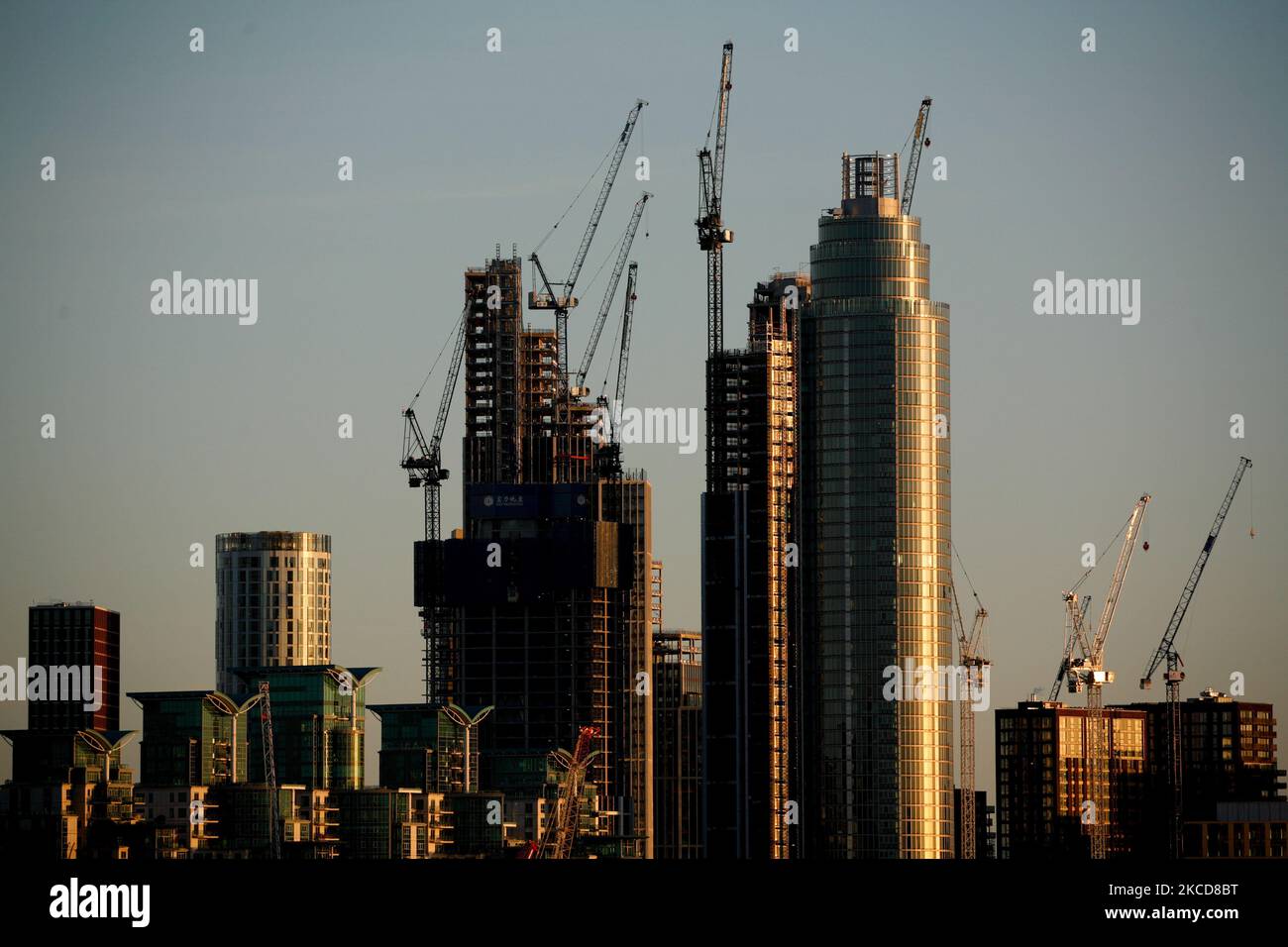 Golden evening sunlight glints off under-construction high rise ...