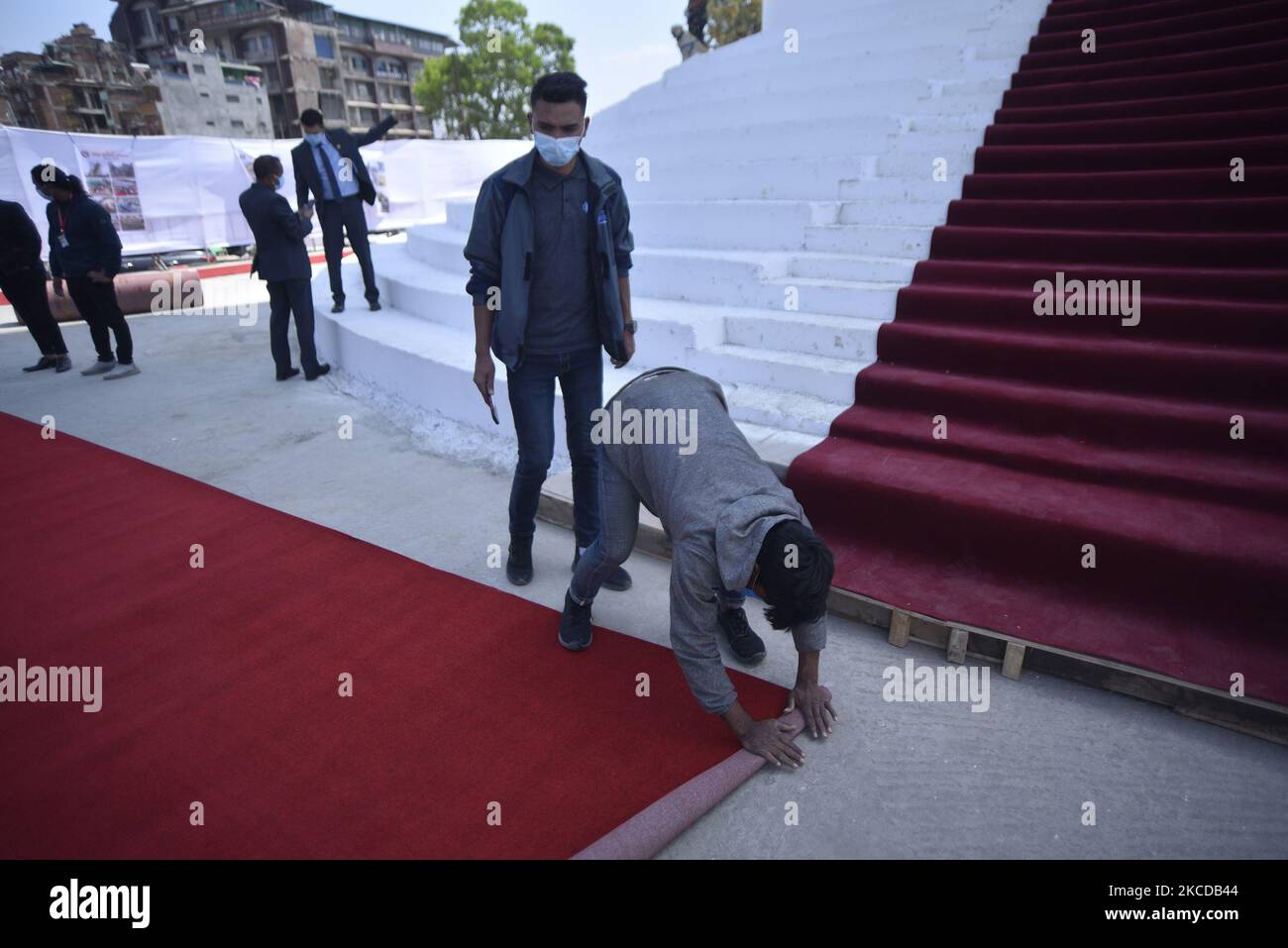 Nepalese workers arrange red carpet for the inauguration around newly ...
