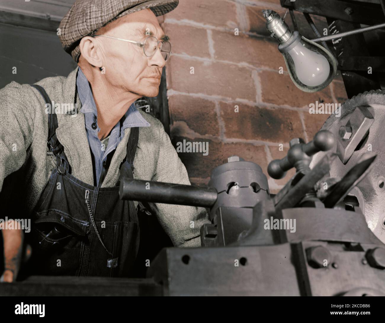 Man working in a small machine shop for war production, circa 1942 ...