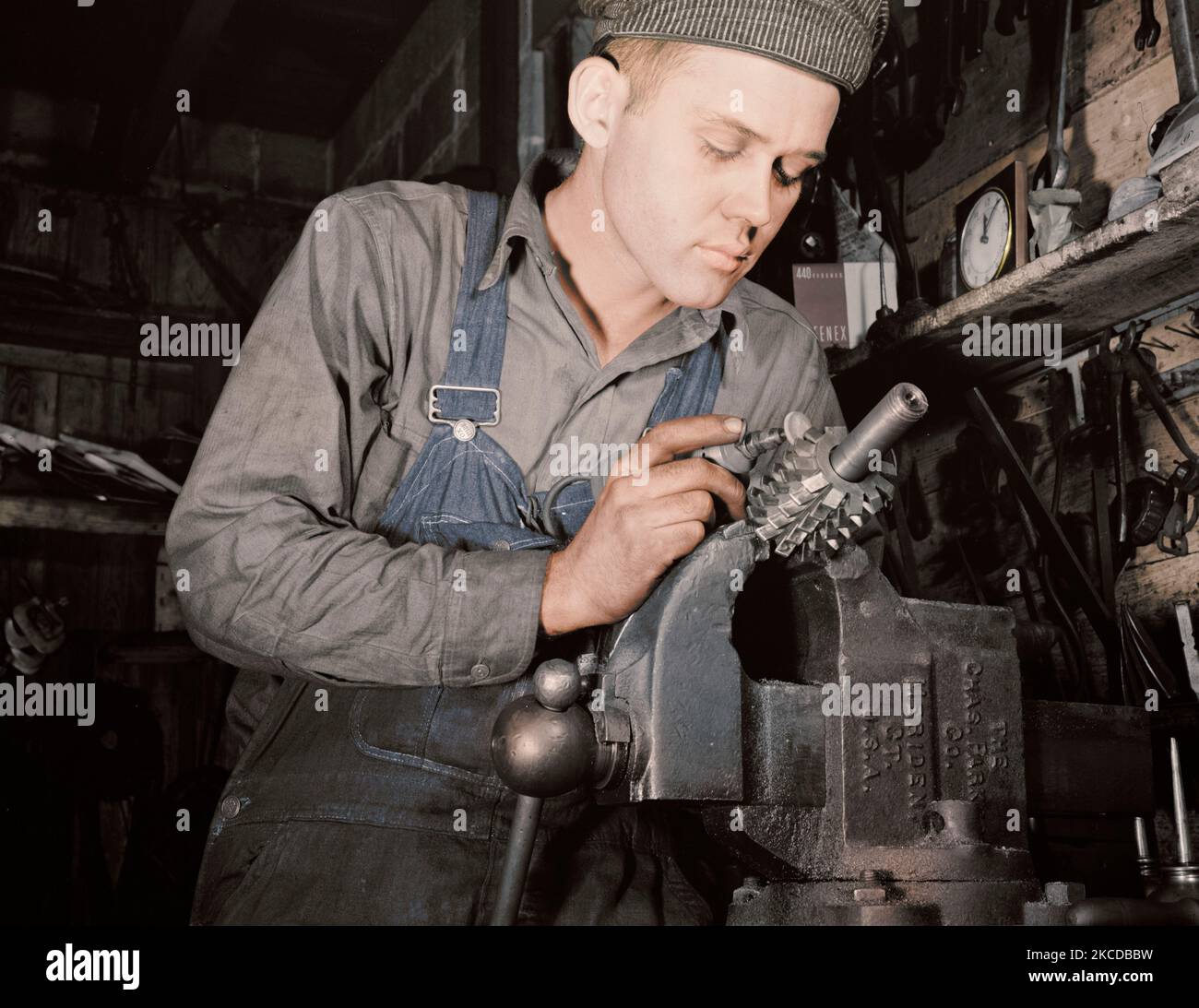Man working in a small machine shop for war production, circa 1942 ...