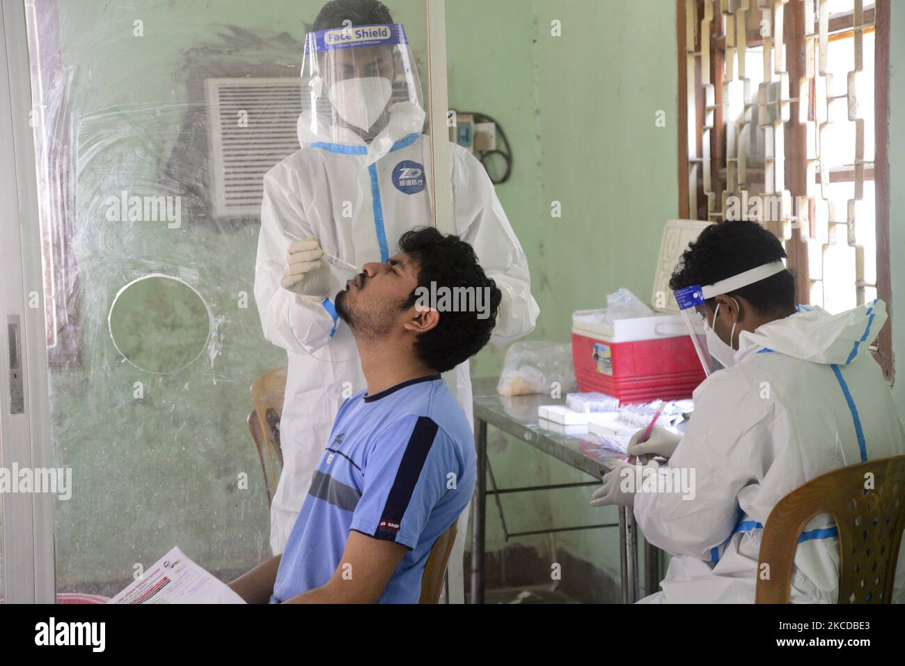 Health worker collects a nasal swab sample of a people to test for the ...
