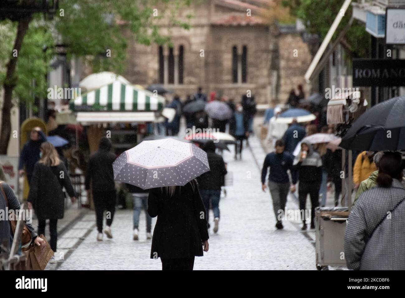 People are walking during a rainy day, wearing protected mask and ...