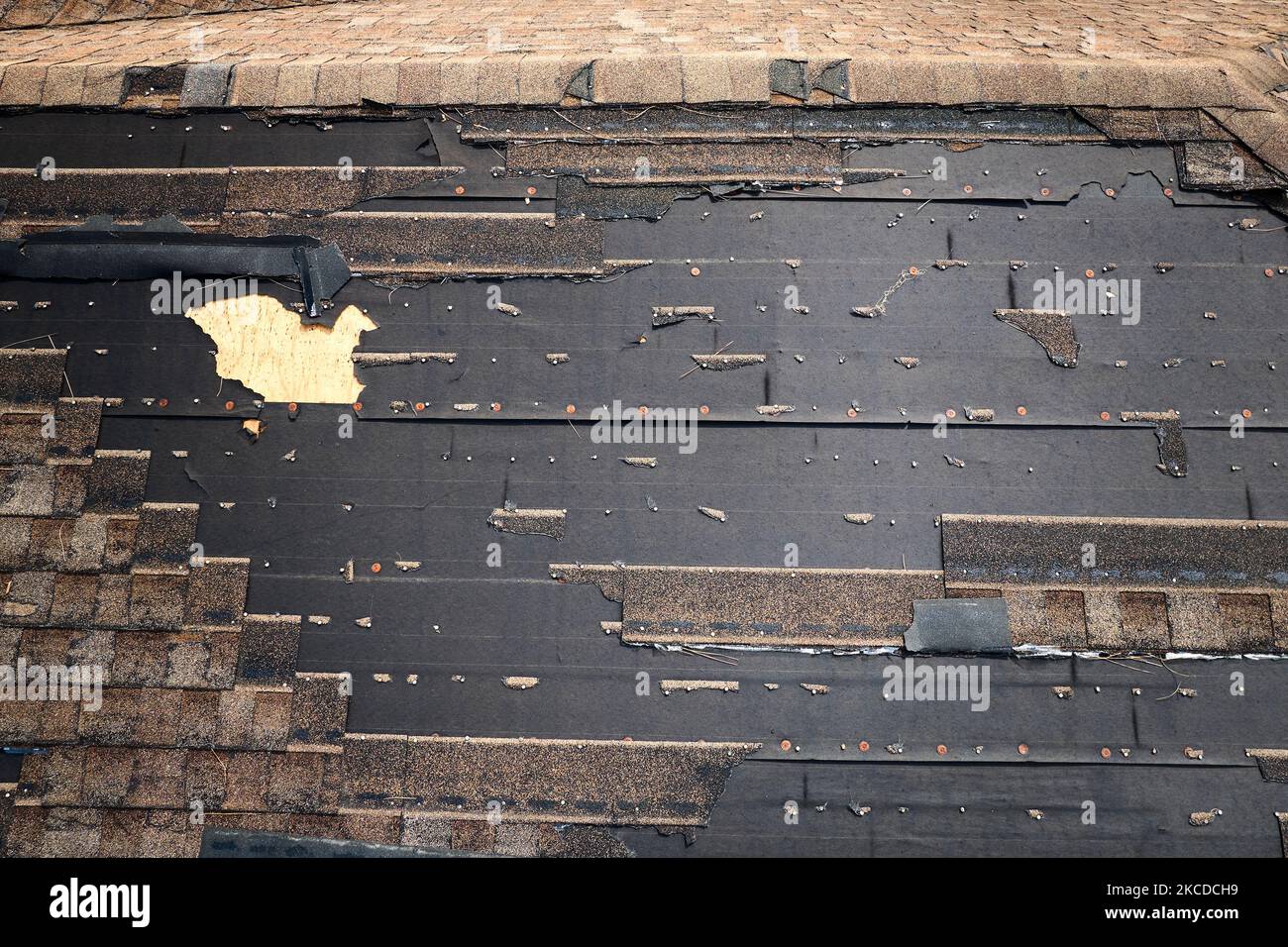 Damaged house roof with missing shingles after hurricane Ian in Florida ...