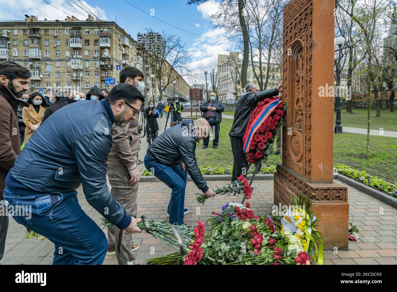 People leave flowers under a khachkar, a memorial stone stele of ...