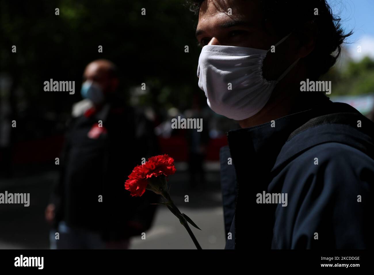People wearing face masks take part in a parade to mark the 47th ...