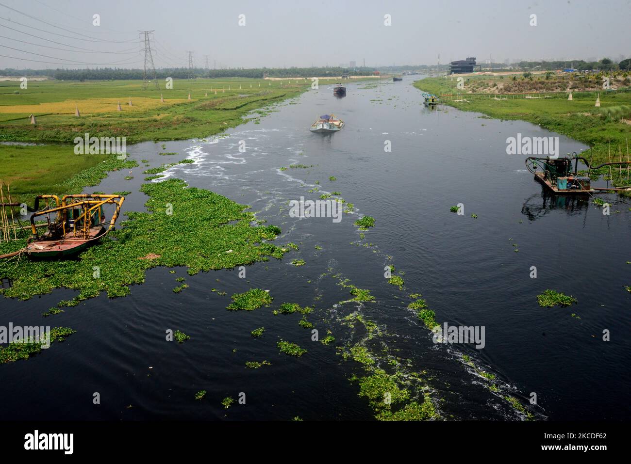 People cross on boat over the pitch black water of the polluted Turag ...